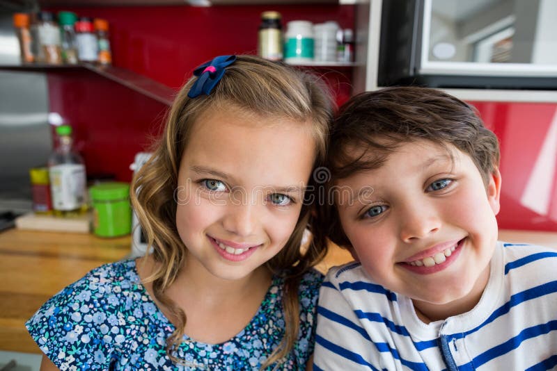 Siblings Smiling at Camera in Kitchen Stock Image - Image of casual ...