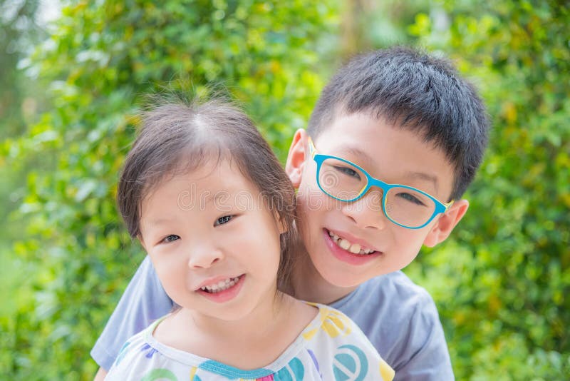 Siblings smiling in park stock photo. Image of children - 79870488