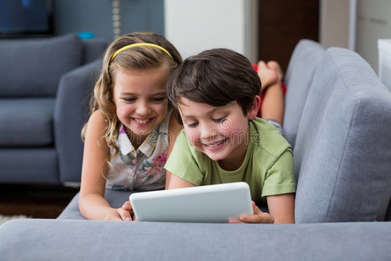 Siblings Using Digital Tablet in Living Room Stock Image - Image of ...