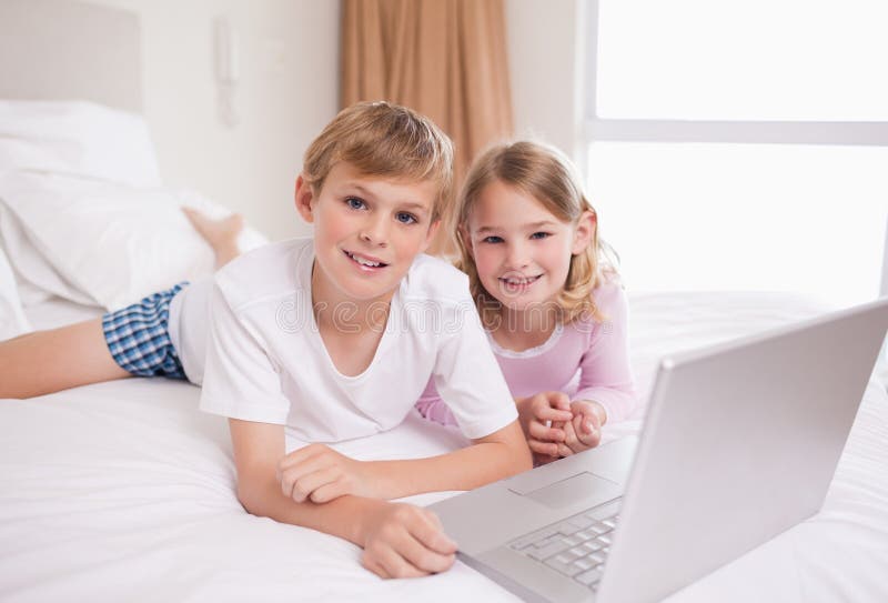 Siblings using a laptop stock image. Image of computer - 22370763