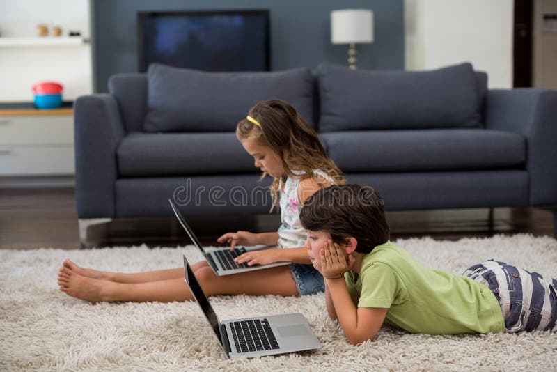 Siblings Using Laptop in Living Room Stock Photo - Image of cute, life ...
