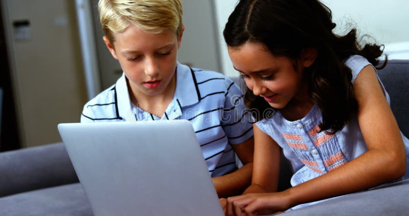 Siblings Using Laptop in Living Room Stock Footage - Video of computer ...
