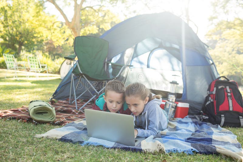 Siblings Using Laptop Outside the Tent Stock Photo - Image of campsite ...