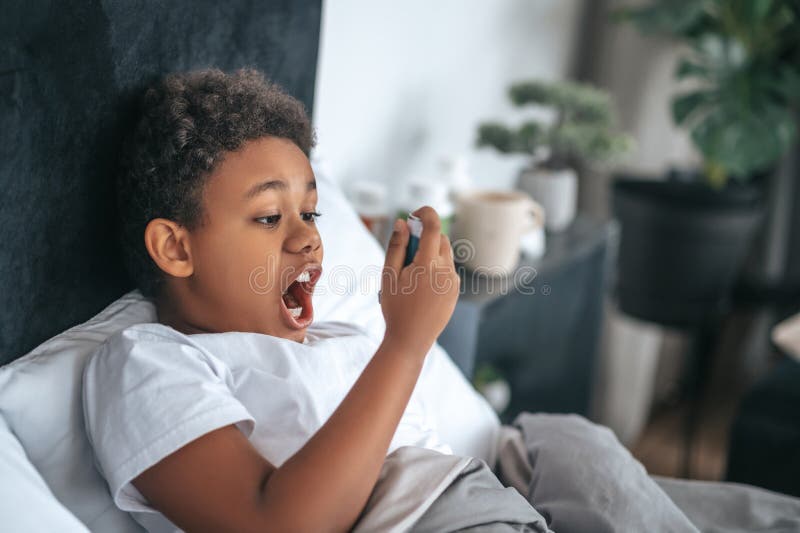Sick Boy Having Sore Throat and Spraying the Remedy Stock Photo - Image ...