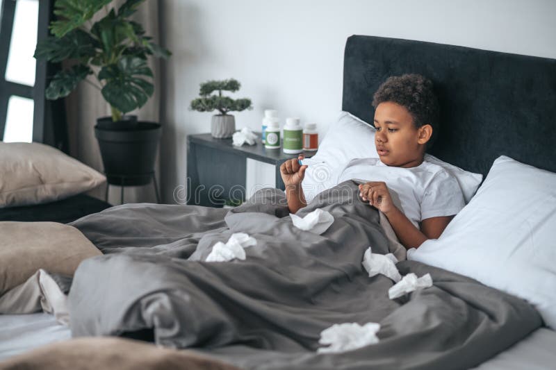 Sick Boy Lying in Bed with Fever and Checking Temperature Stock Image ...