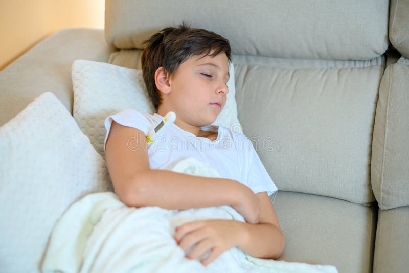 Sick Child Lying on the Sofa at Home. Child Has Thermometer Under His ...
