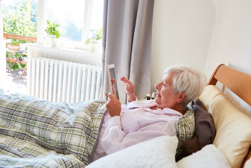 Sick Elderly Woman in Bed in the Retirement Home while Video Chat Stock ...