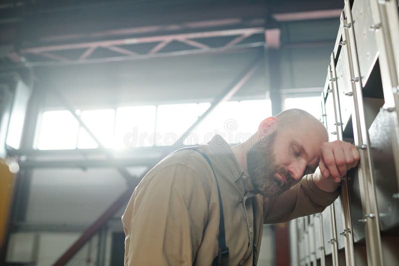 Sick or Exhausted Factory Worker Standing by Metallic Construction ...