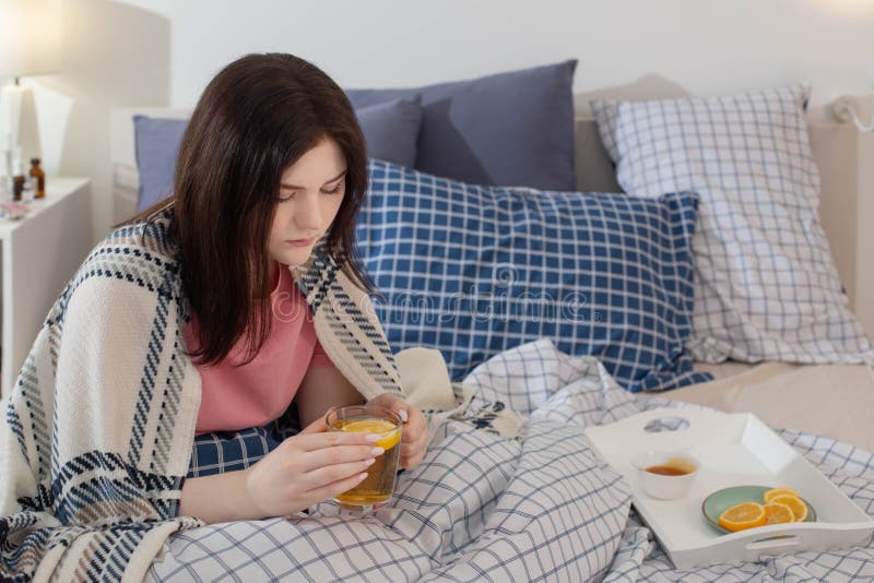 Sick girl with tea in bed stock image. Image of indoor - 238955809