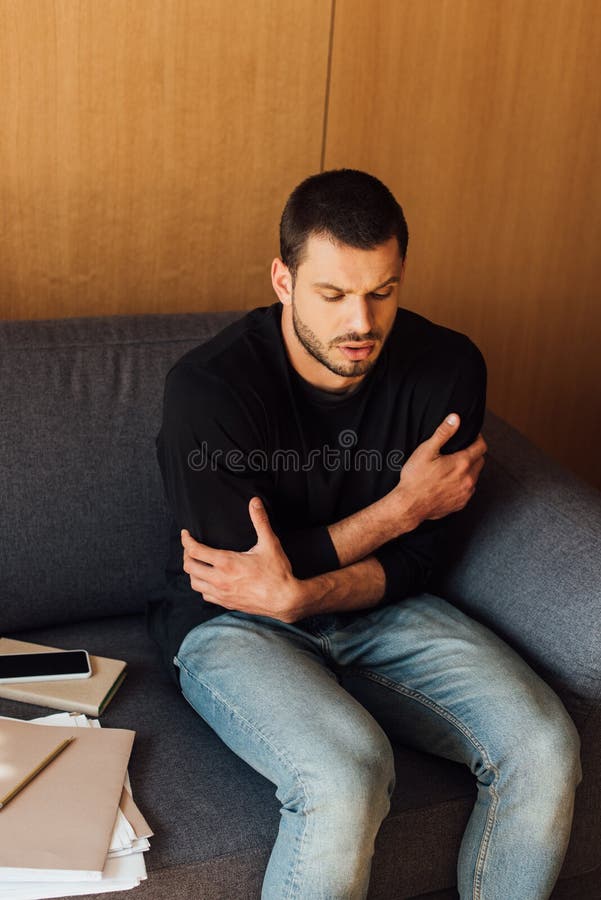Man Feeling Cold while Sitting on Sofa Near Smartphone with Blank ...