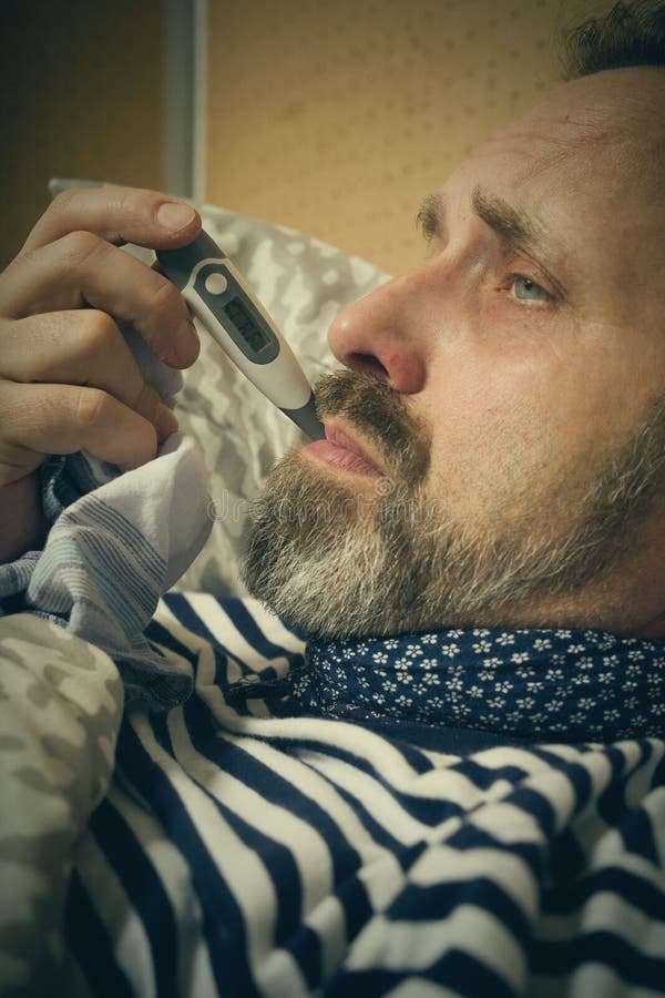 Sick Man with Flu and Cold Checking His Teplerature with Thermometer ...