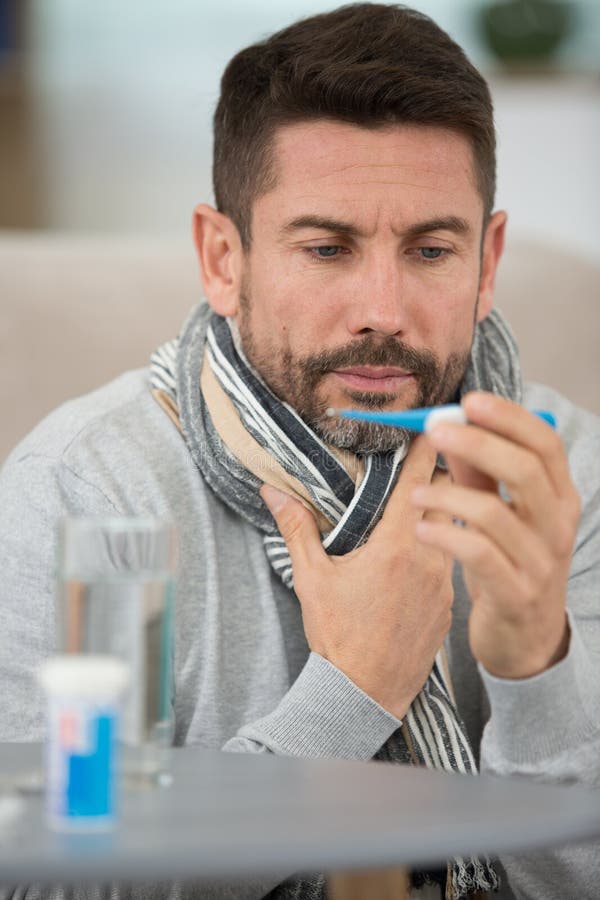 Sick Man Lying on Sofa Checking Temperature at Home Stock Image - Image ...