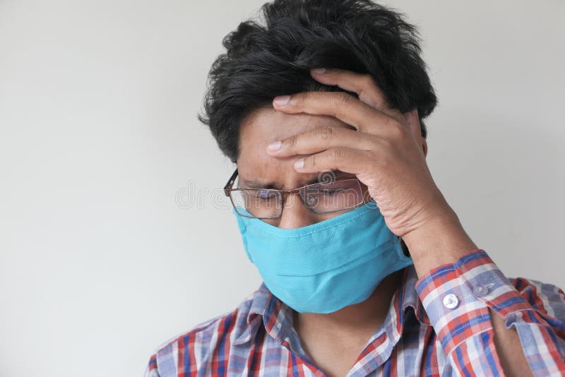 A Sick Man with a Mask on His Face Suffering Headache Stock Photo ...