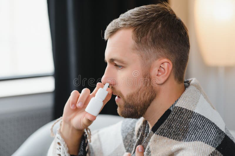 Sick Man with Nasal Spray and Paper Tissue at Home Stock Photo - Image ...