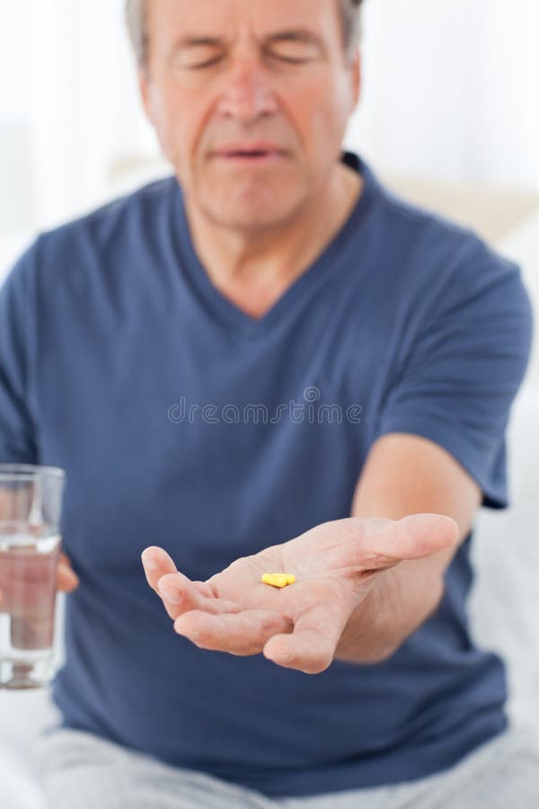 Sick man taking his pills stock image. Image of relief - 18109551