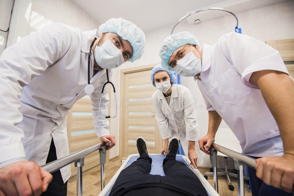 Sick Patient on Gurney in Operating Room with Doctors in Front of Him ...