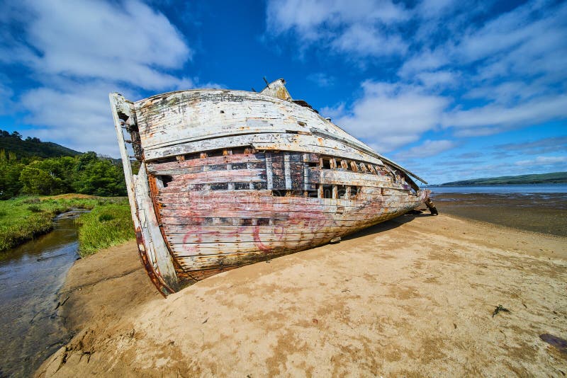 Side Hull of Red and White Shipwreck on Sandy Beaches with Blue Sky ...