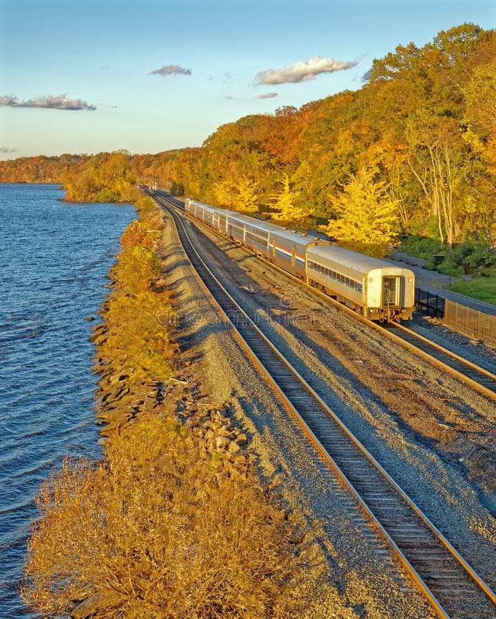 Side Lit Amtrak Train Traveling on Tracks Alongside Hudson River in ...