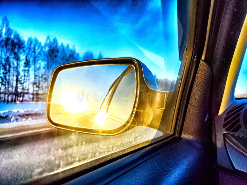 The Side Mirror of the Car and the Sun with Bright Rays in it and the ...