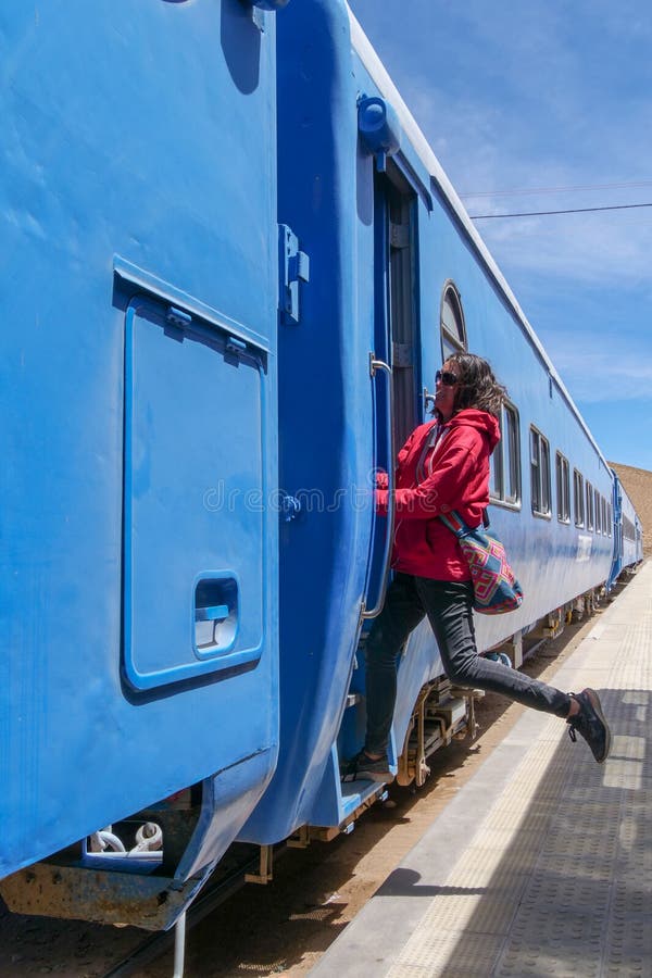 Side Profile Of A Female Tourist Embarking A Blue Train Carriage