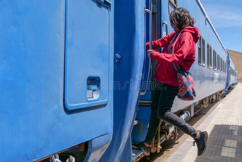 Side Profile Of A Female Tourist Embarking A Blue Train Carriage