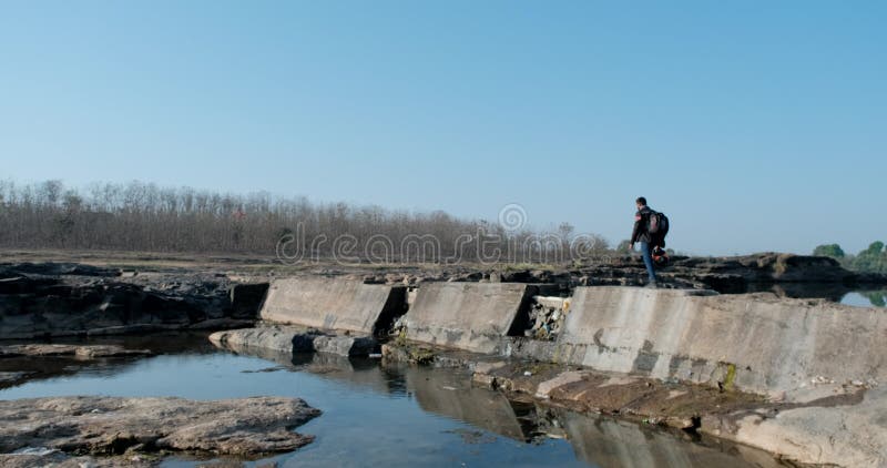 Side Shot of a Man with a Backpack Crossing the River Over Bridge ...