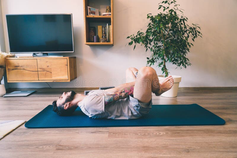 Side Shot of Man Practicing Yoga Wind Relieving Pose at Home Stock ...