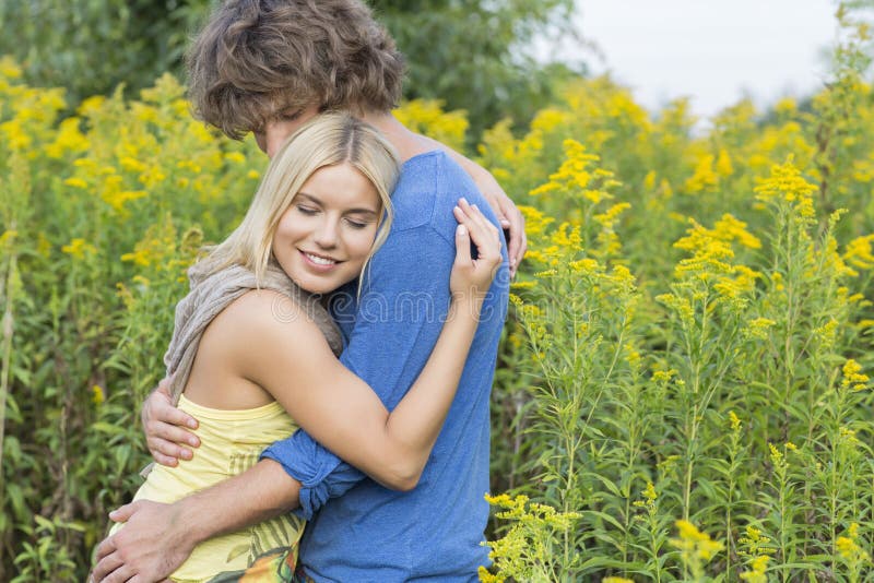 Side View of Affectionate Couple Hugging in Field Stock Image - Image ...