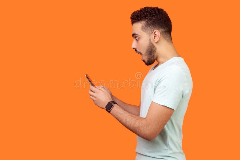 Side View of Amazed Brunette Man Looking Shocked at Mobile Phone. Empty ...