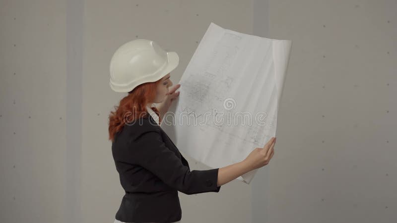 Side View of an Architect Woman Holding a Plan in Her Hands. a Woman is ...