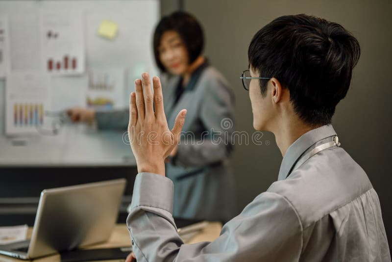 Side View of Asian Male Worker Raising Hand To Asking Question on a ...
