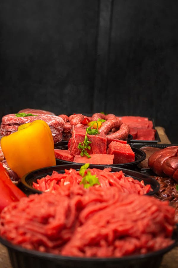 Side View of Assorted Raw Beef Products on Table with Black Background ...