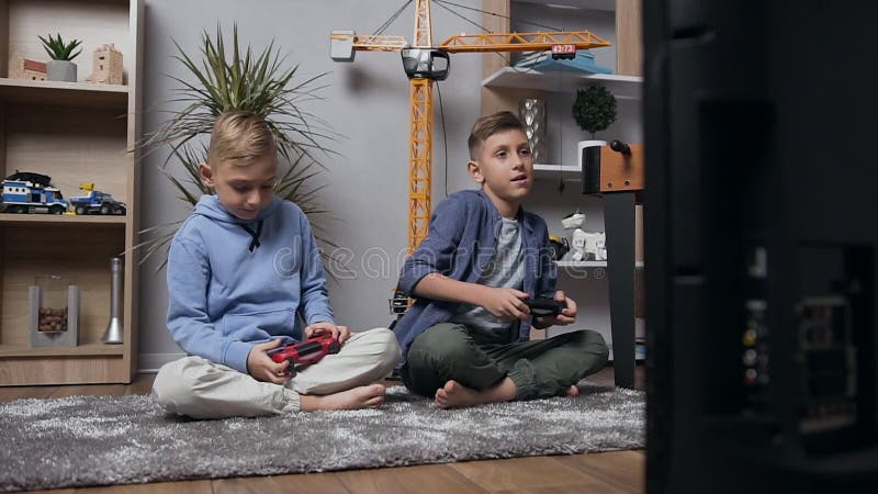 Handsome Concentrated Teen Boys Sitting on the Carpet and Playing Video ... Handsome Concentrated Teen Boys Sitting on the Carpet and Playing Video ...