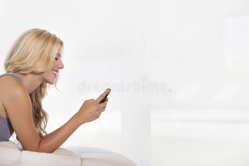 Side View of Beautiful Young Woman Reading Text Message on Cell Phone ...