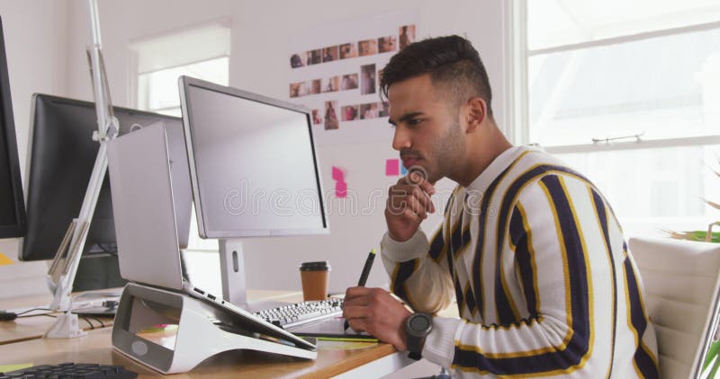 Side View of a Biracial Man Working in a Creative Office, Using ...