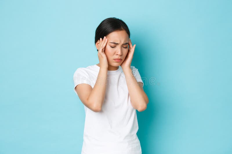 Side View Of Bothered Tired Asian Girl Grimacing Touching Head And