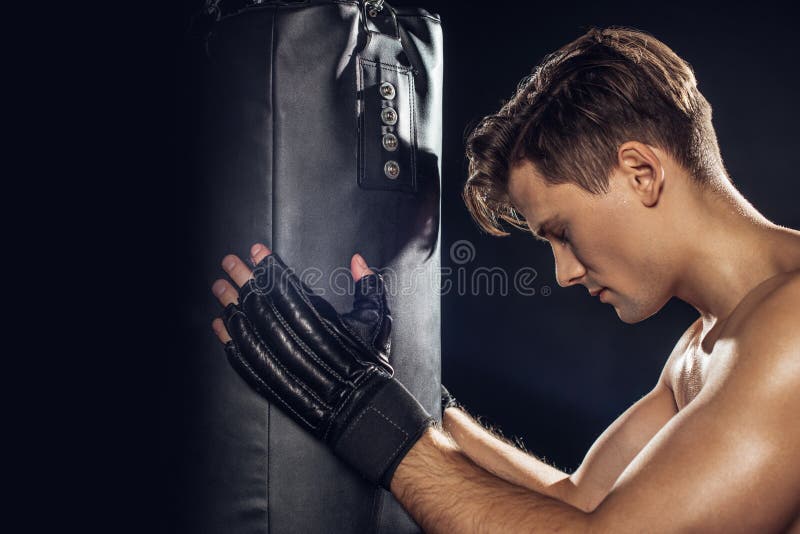 Side View of Boxer Holding Punching Bag with Closed Eyes on Black ...
