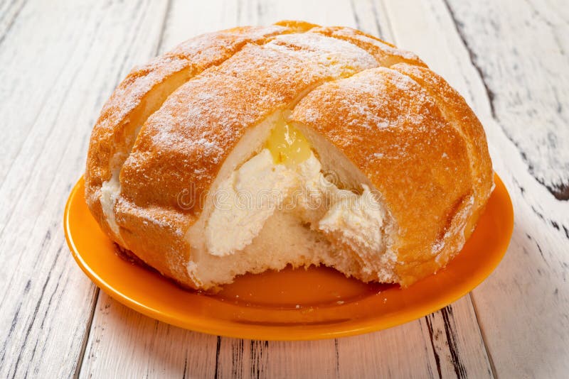 Bread with Cream Inside with a Bite on Wood Table Stock Photo - Image ...