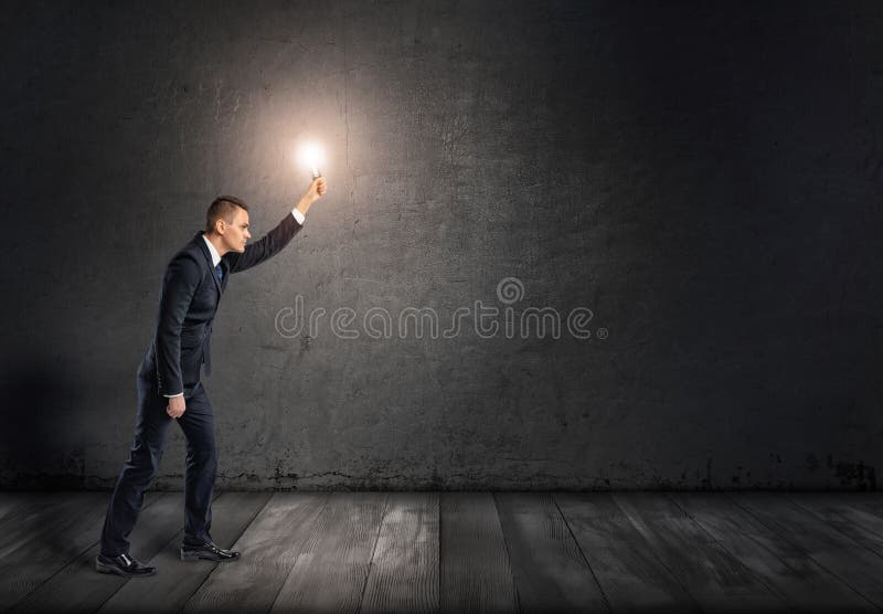 Side View of a Businessman with Glowing Light Bulb in Outstretched Arm ...