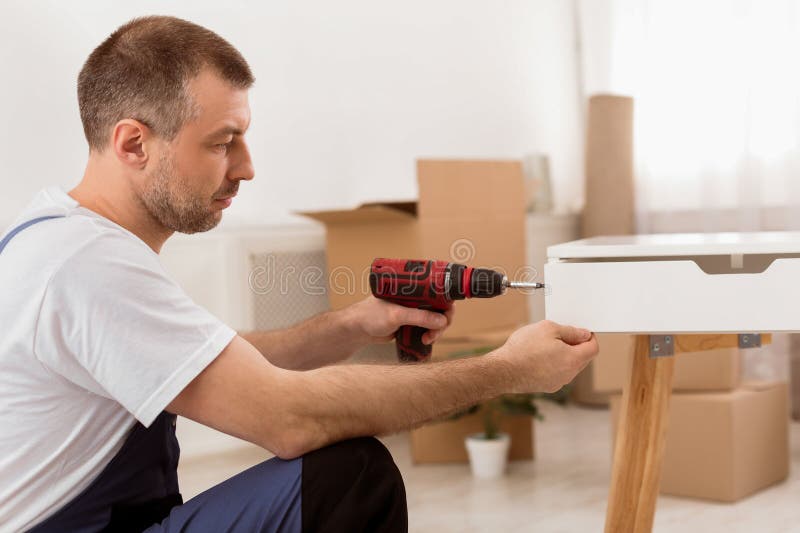 Side-View of Carpenter Man Assembling Table Using Electric Drill ...