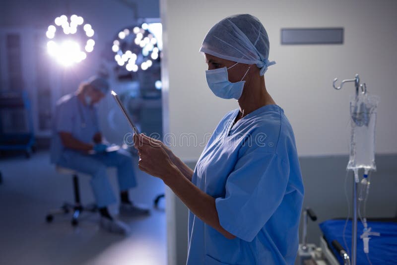 Female Surgeon Using Digital Tablet in Operation Room Stock Photo ...