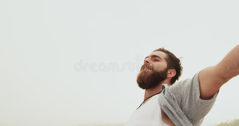 Side View of Caucasian Man Standing with Arms Outstretched on the Beach ...