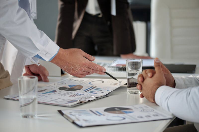 Doctors Discussing Medical Data Pointing at Clipboard with Statistics ...