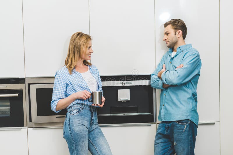 Side View of Couple Having Conversation in Kitchen Stock Photo - Image ...