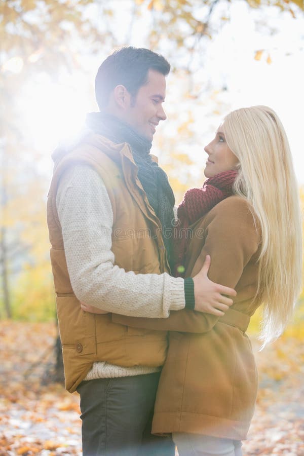 Young Couple Enjoying Falling Autumn Leaves in Park Stock Photo - Image ...