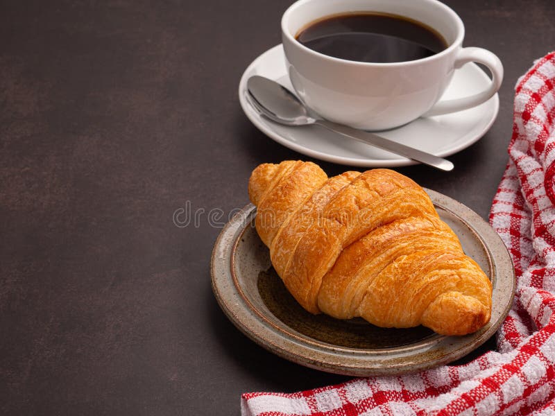 Side View of a Croissant on a Plate and a White Coffee Cup with a Cloth ...