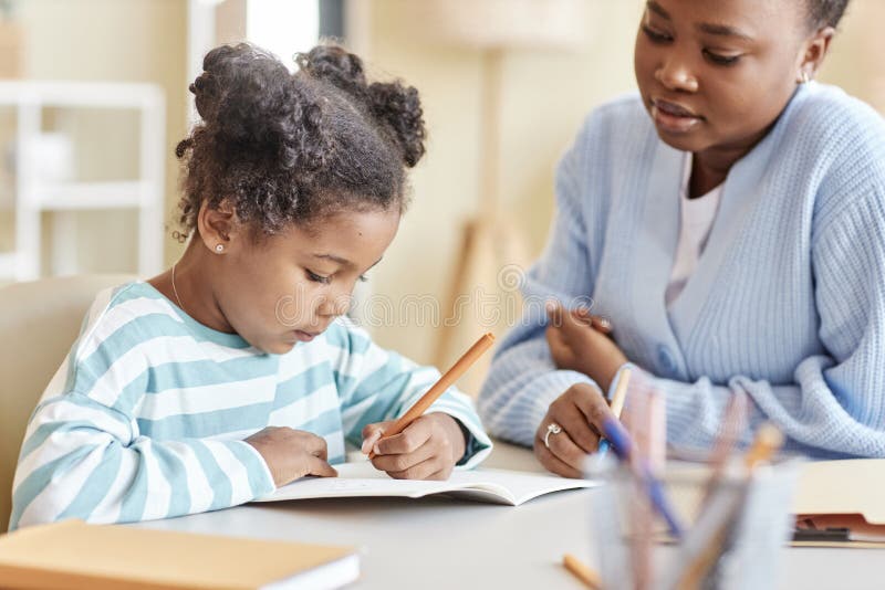 Side View Cute Black Girl Studying with Tutor and Writing in Notebook ...