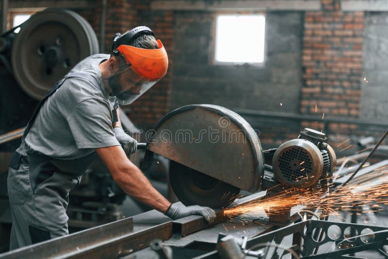 Side View, Cutting the Metal. Young Factory Worker in Grey Uniform ...