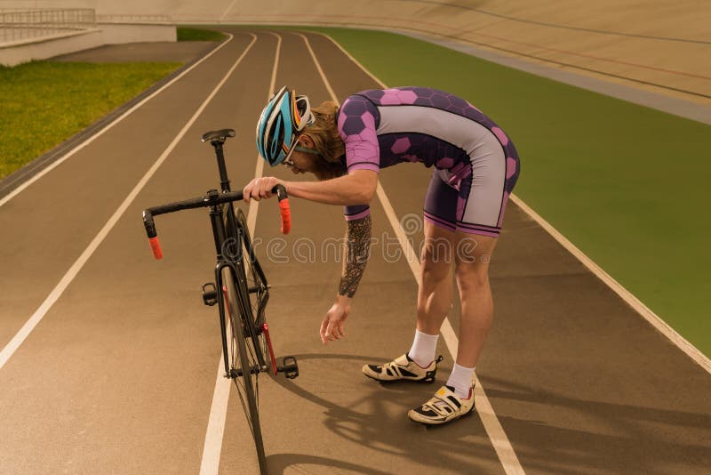 Side View of Cyclist Checking Bicycle Wheel while Standing on Cycle ...