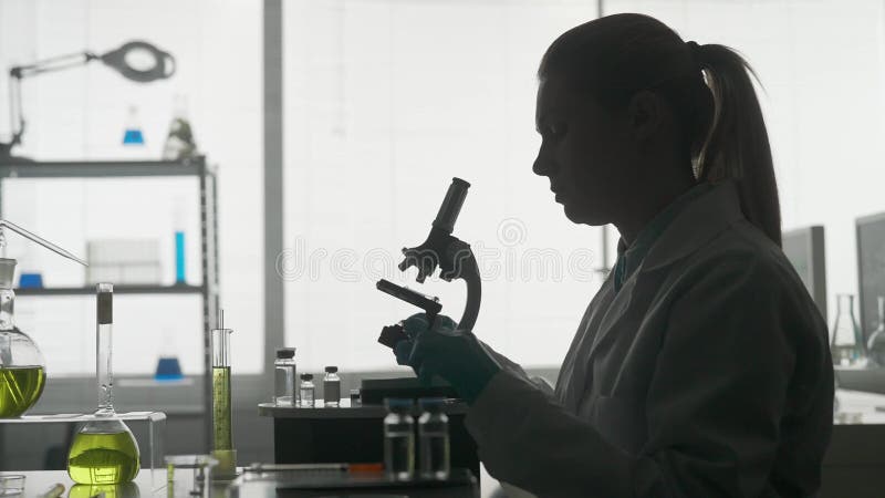 Side View of a Dark Silhouette of a Female Scientist Looking Under a ...